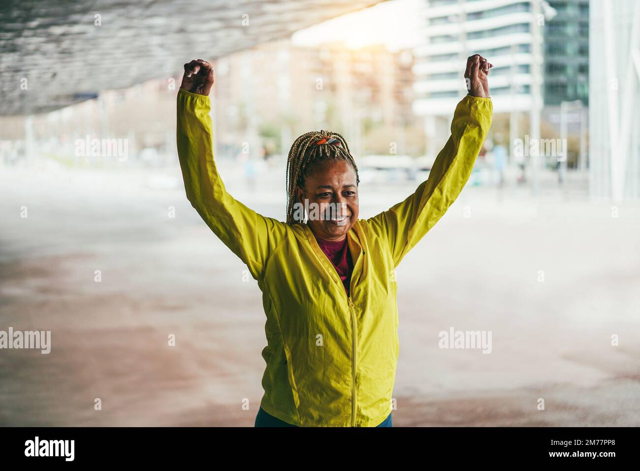 Senior african woman stretching during workout routine outdoor - Focus ...
