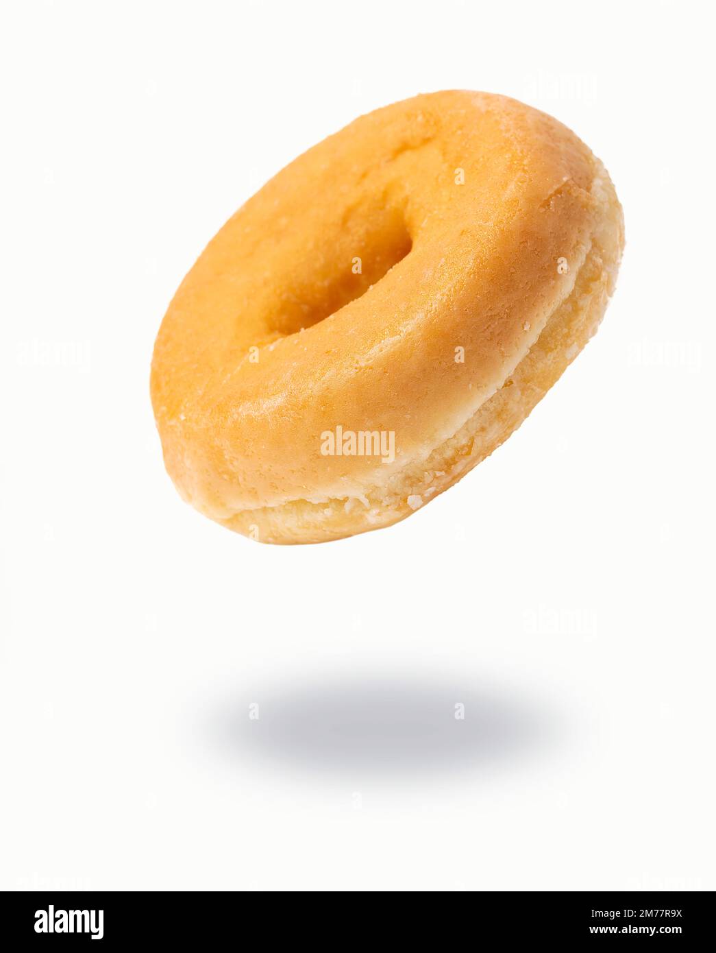 Freshly baked flying sugar plain donut on white background Stock Photo ...