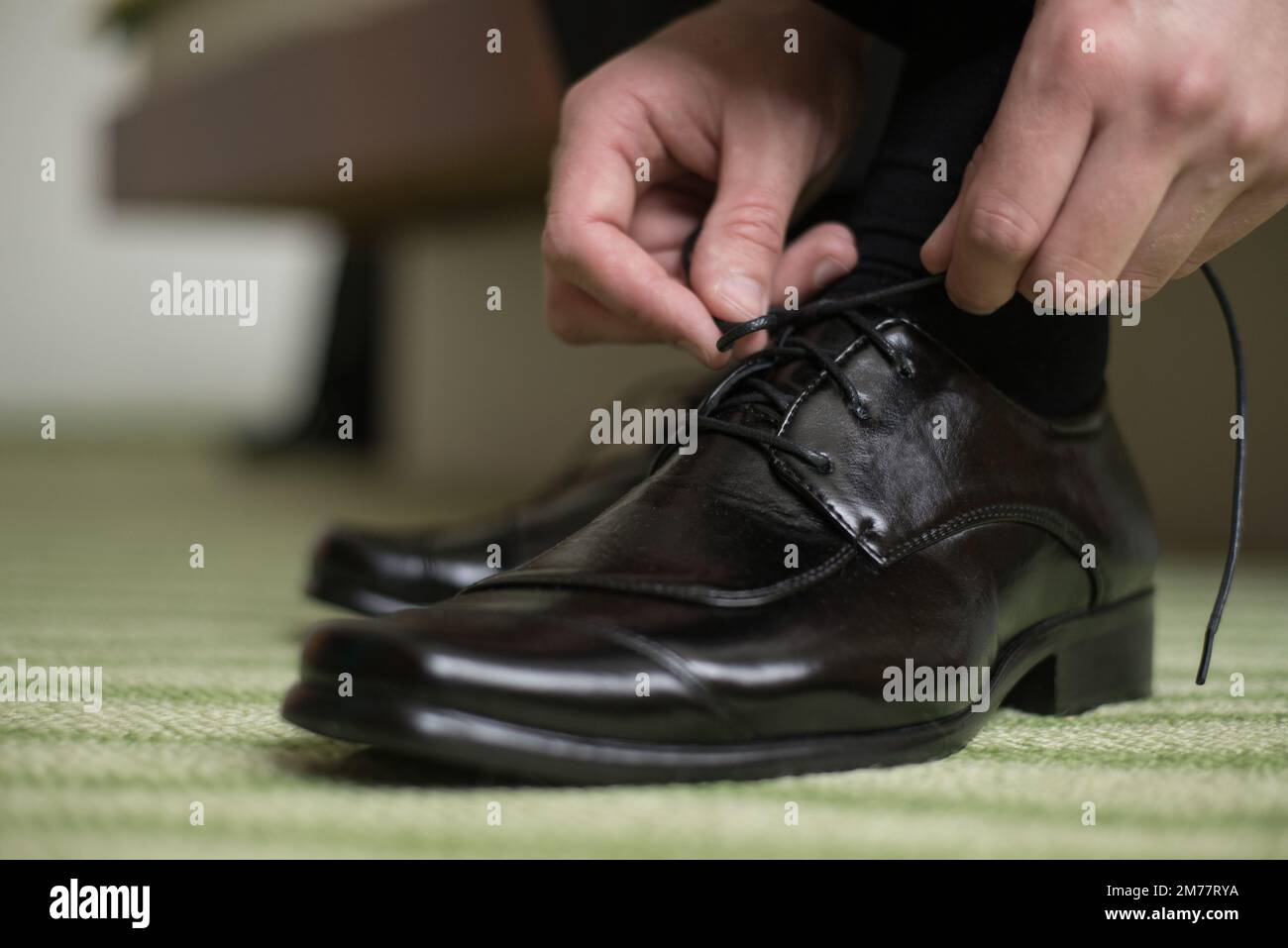 the groom puts on his wedding shoes before the ceremony Stock Photo - Alamy