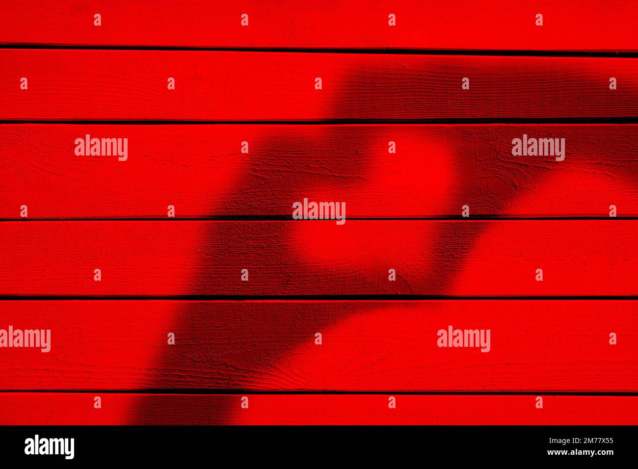 Two hands forming a heart shadow on red wood background Stock Photo - Alamy