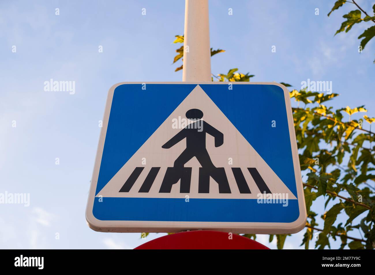 The pedestrian crosswalk sign against the blue sky with clouds Stock ...
