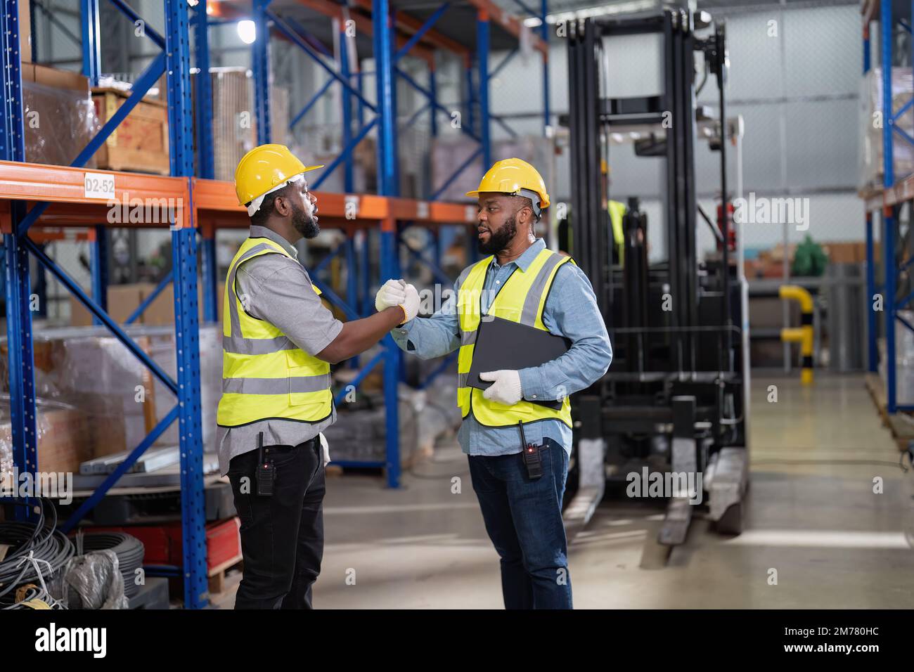 African american working in warehouse check forklift truck loading ...