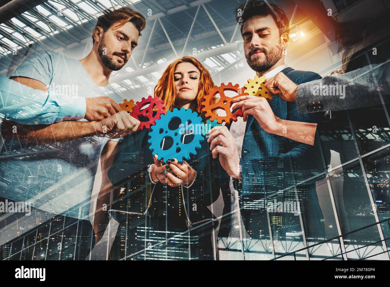 Teamwork of businesspeople work together and combine pieces of gears as ...