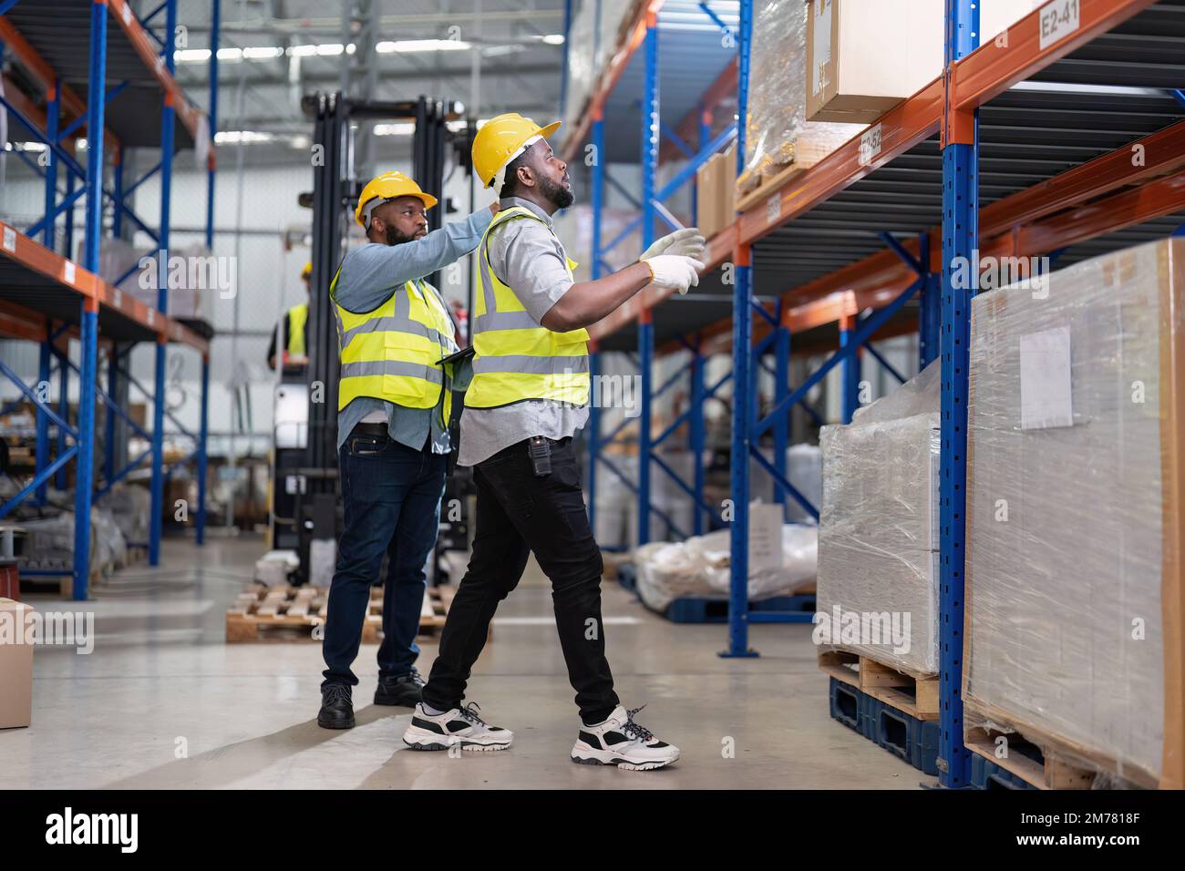 African american working in warehouse hold stock check list while truck ...