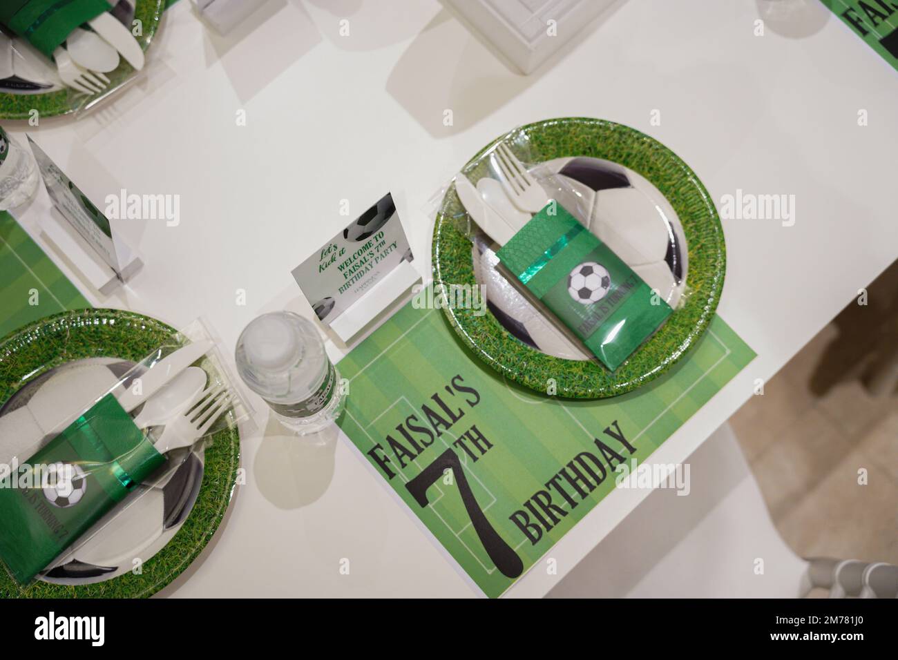 Kids' soccer or football-themed party table with plastic cutlery and ...