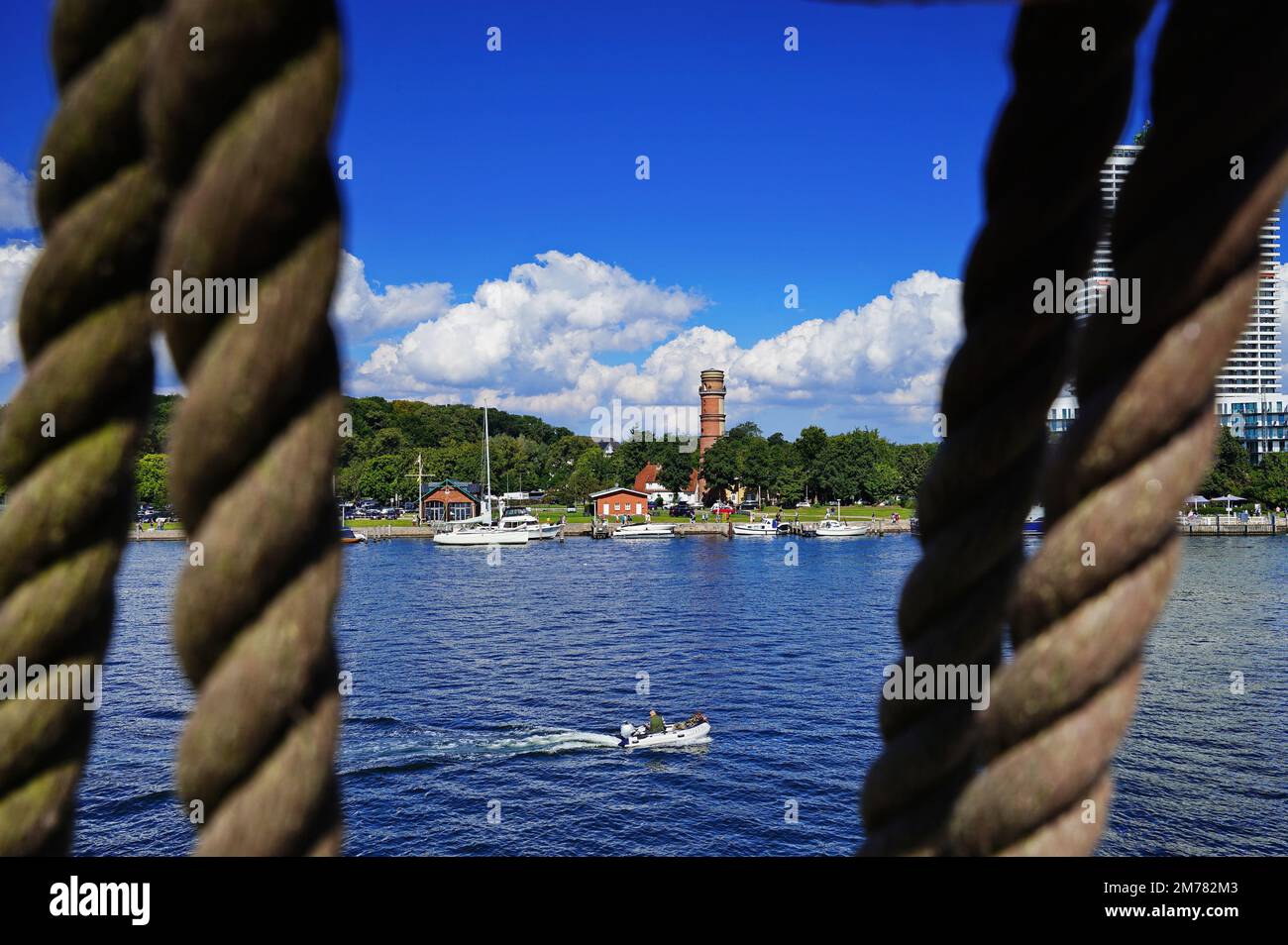 A boat sailing on the Trave river surrounded by traditional buildings ...