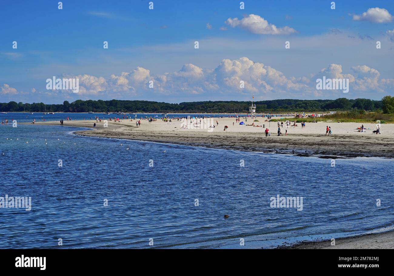 A scenic view of people relaxing at a sandy Travemunde Strand beach on ...