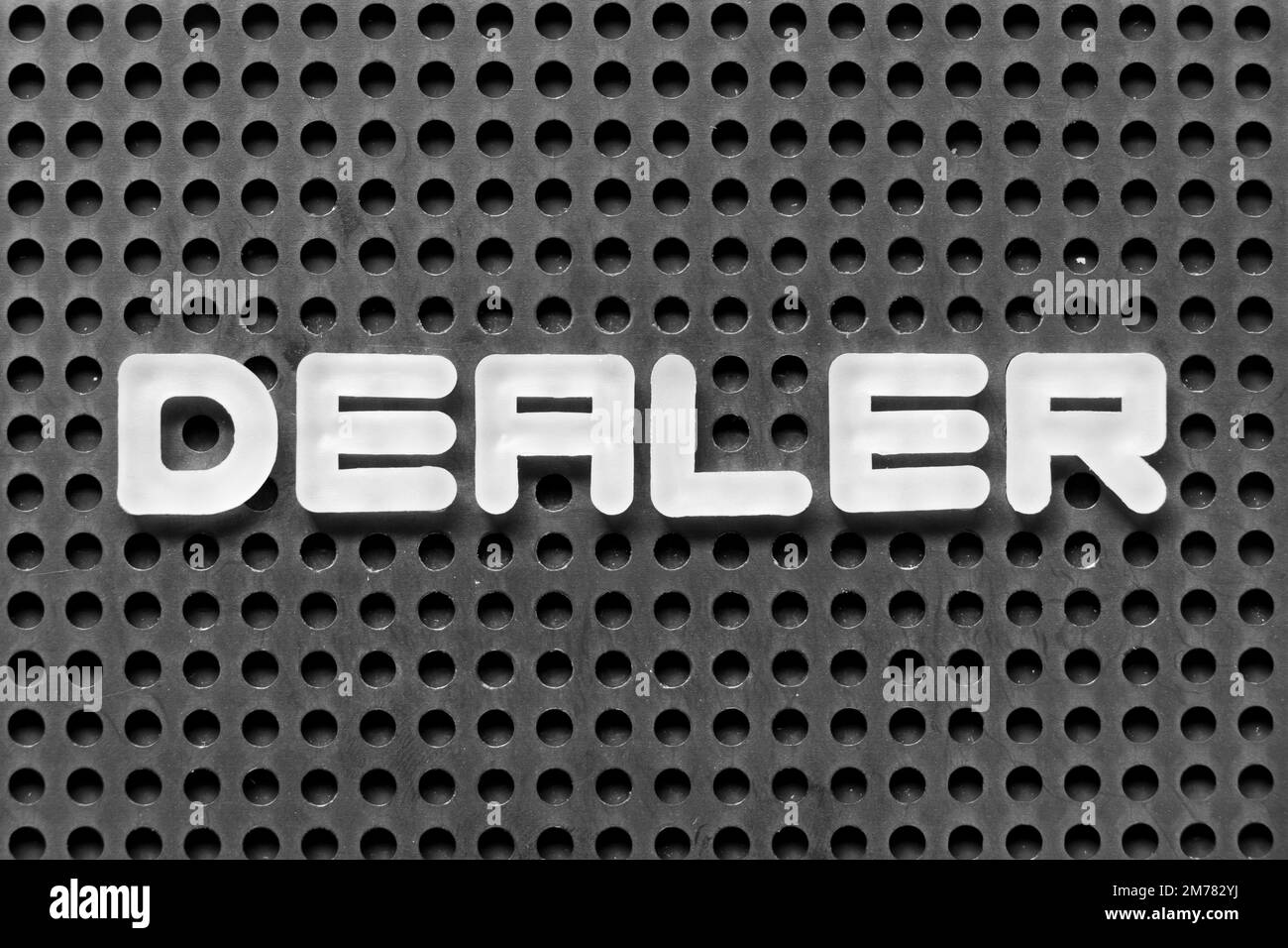 White alphabet letter in word dealer on black pegboard background Stock ...