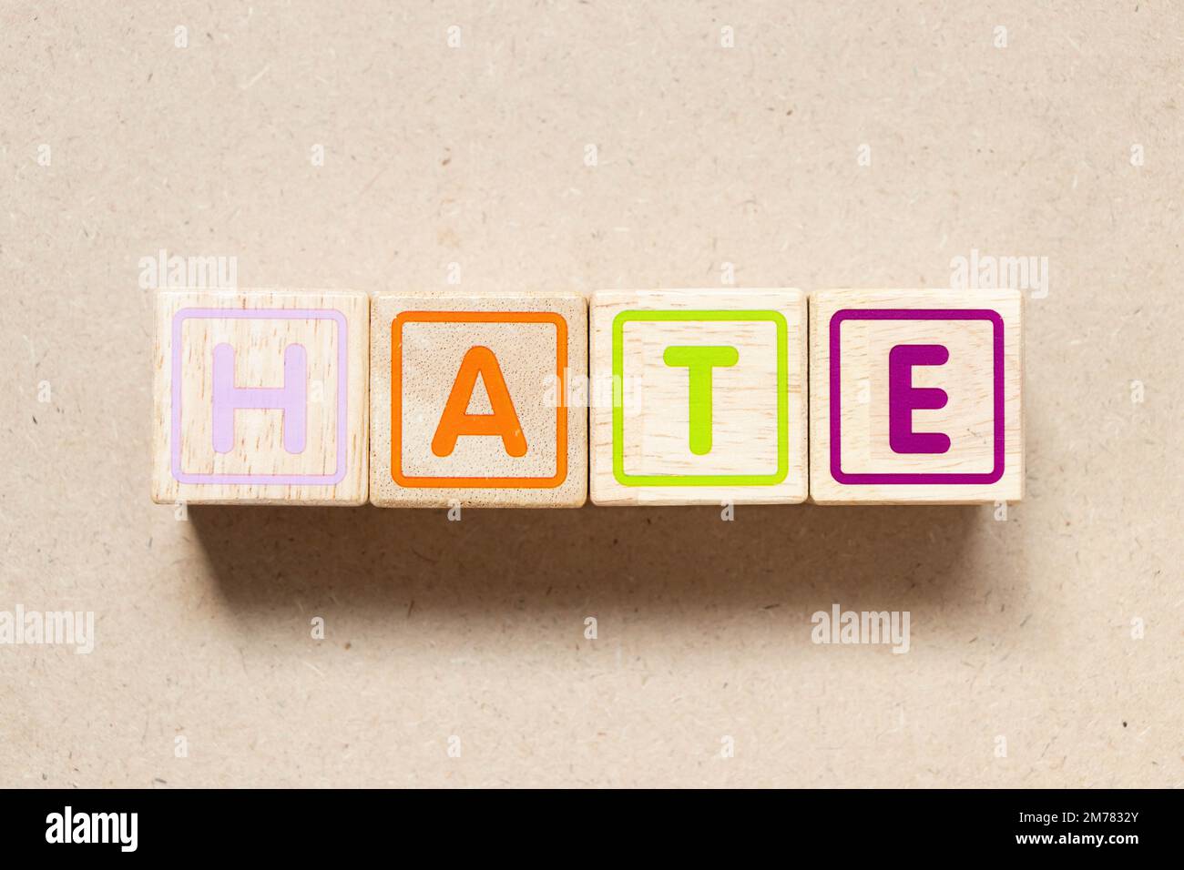 Color letter block in word hate on wood background Stock Photo - Alamy