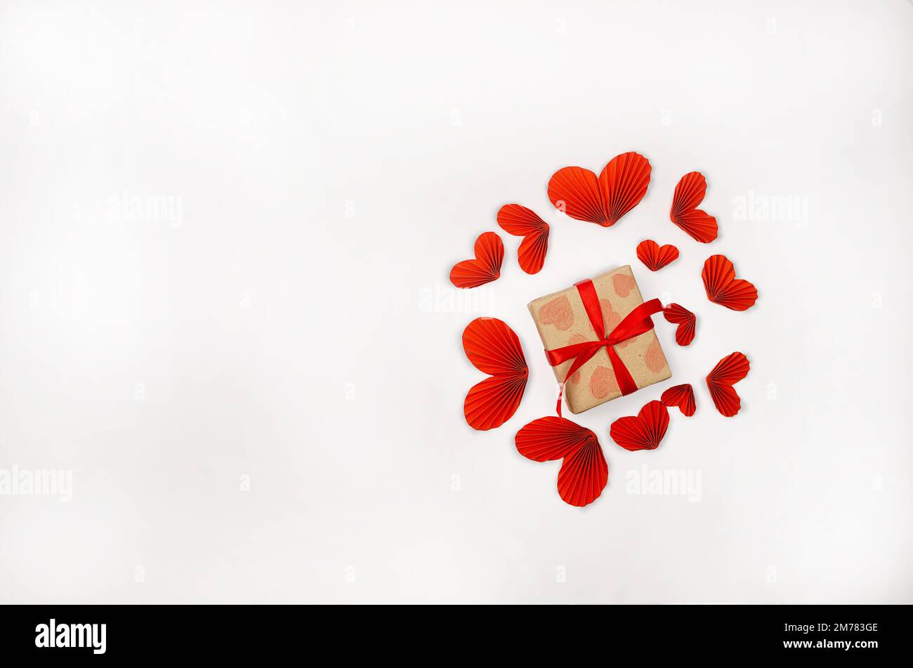 Present Gift box wirh red ribbon and red paper hearts on white ...