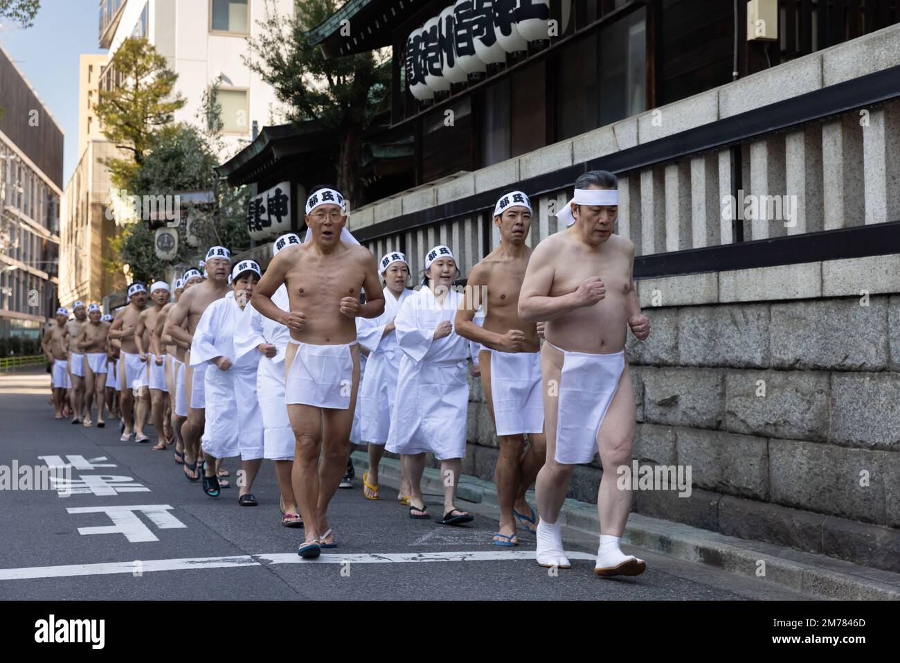 Participants of the 68th Teppozu Inari Shrine Kanchu Suiyoku event are ...