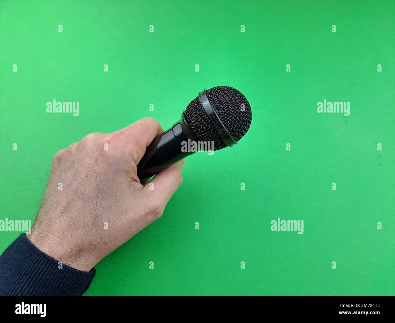 Microphone Close-up Isolated, Adult hand, green color background Stock ...