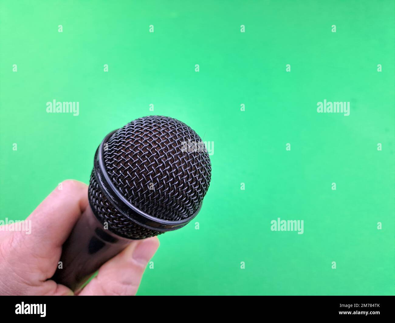 Microphone Close-up Isolated, Adult hand, green color background Stock ...
