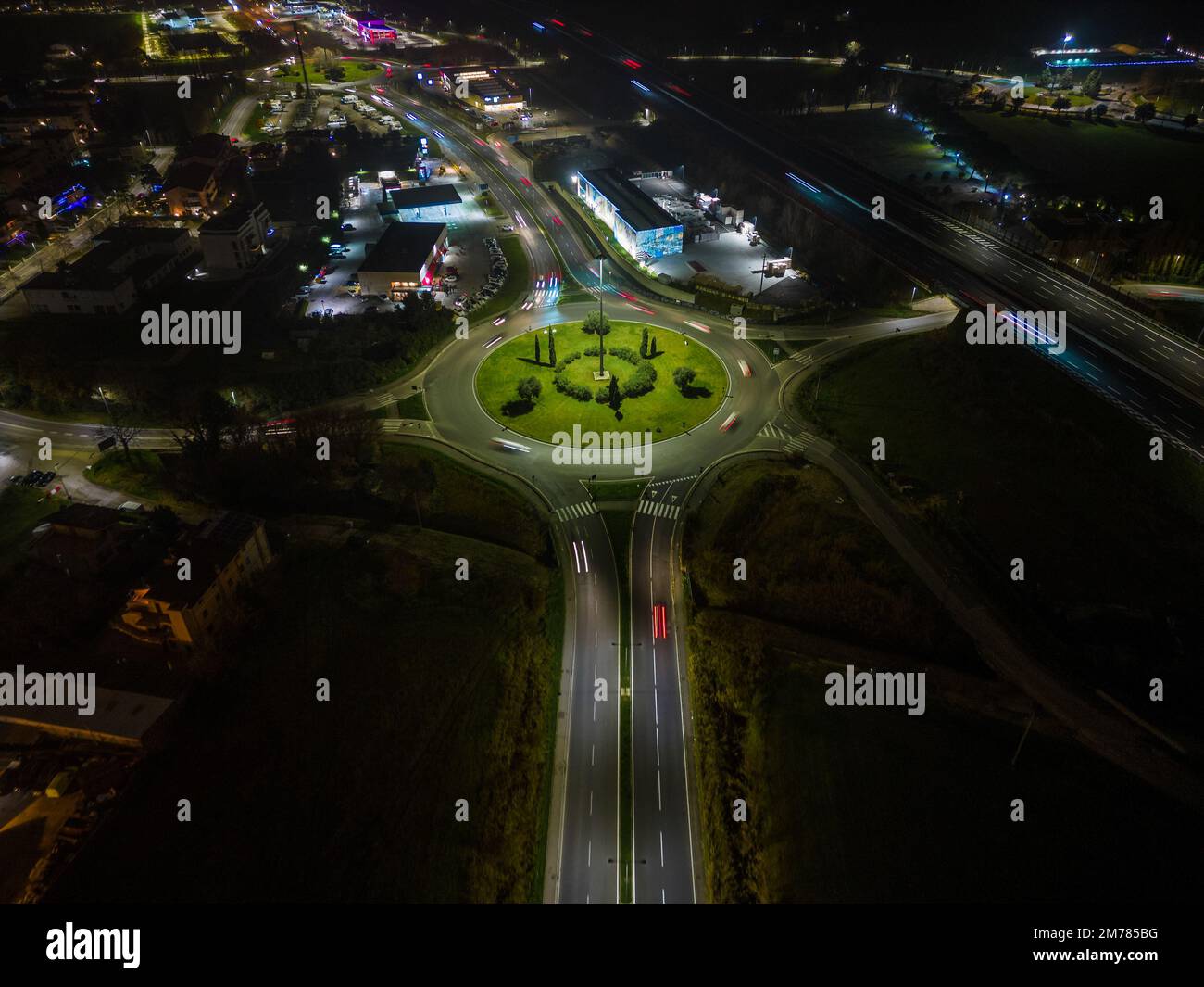 night view of a road busy with cars regulated by a roundabout. the slow ...