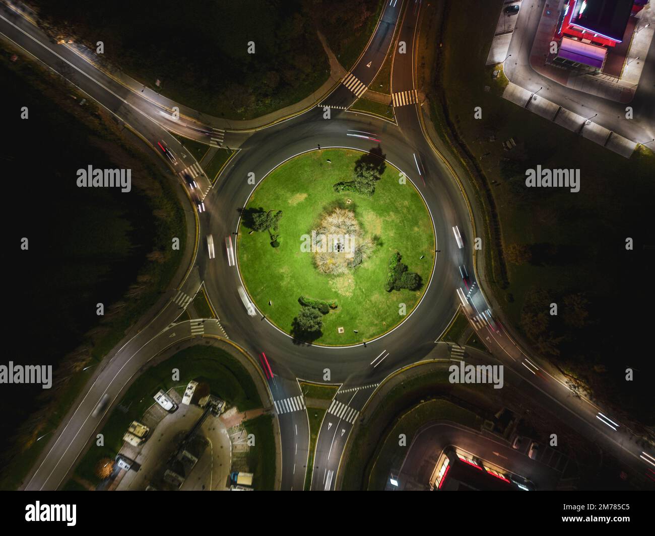 night view of a road busy with cars regulated by a roundabout. the slow ...