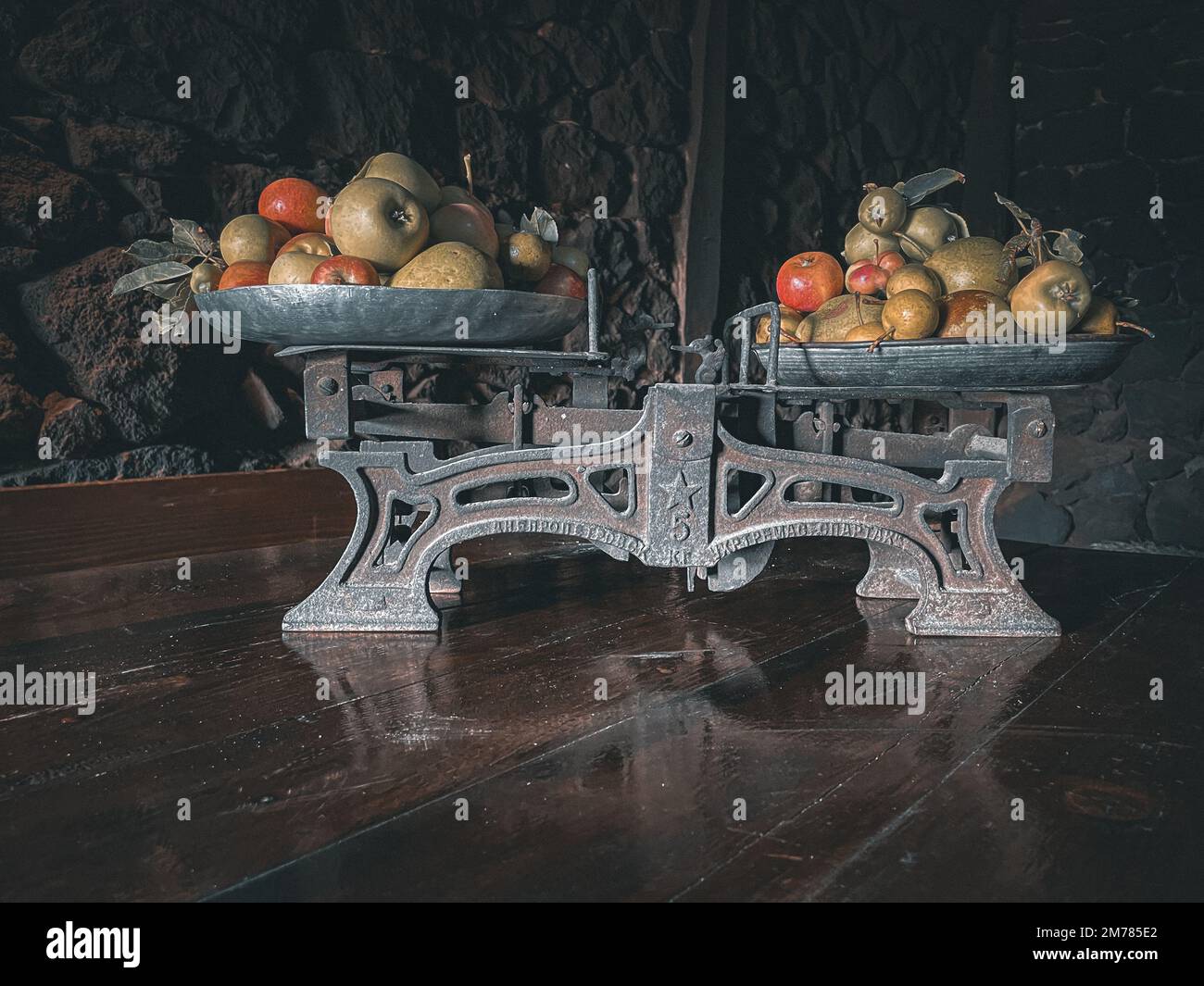 The two plates full of fruits on a retro scales with stone wall in ...