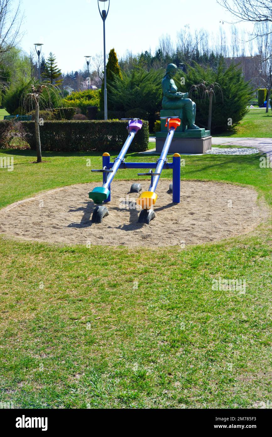 Seesaw at park and a sculpture at the background in a sunny summer day ...