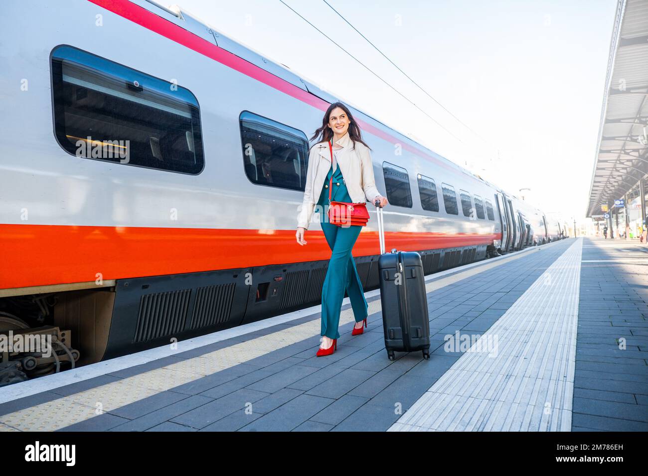 Portrait of a business woman commuter walking in a train station or ...