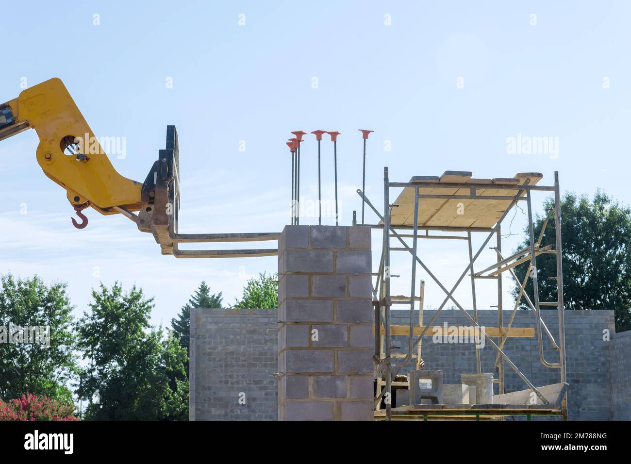 Boom forklift unload concrete blocks in pallets which are being used on ...