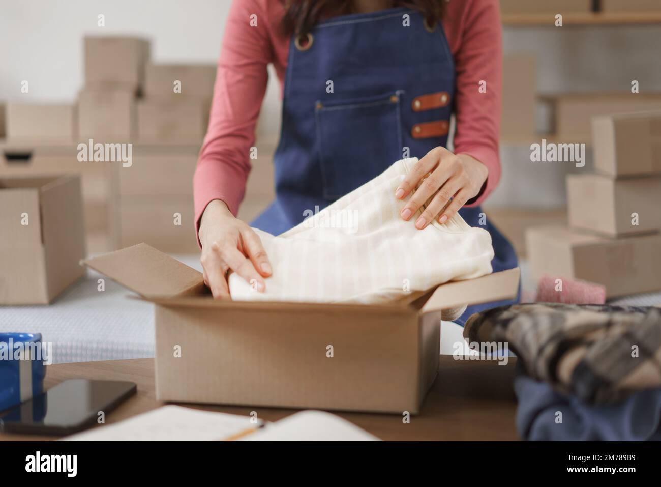 Online shopping business concept, Women entrepreneur packing clothes in ...