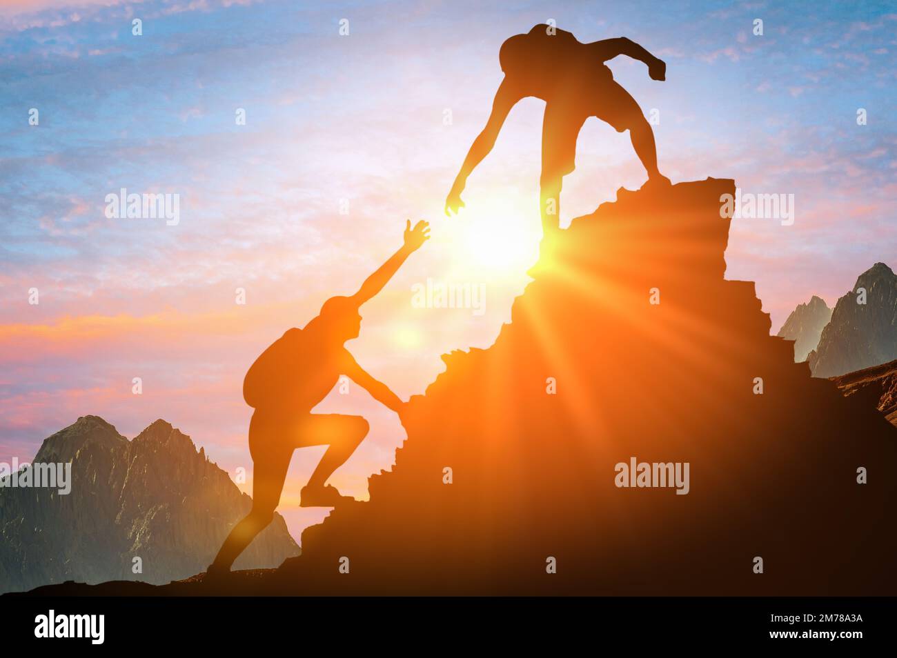 Help and assistance concept. Silhouettes of two people climbing on ...
