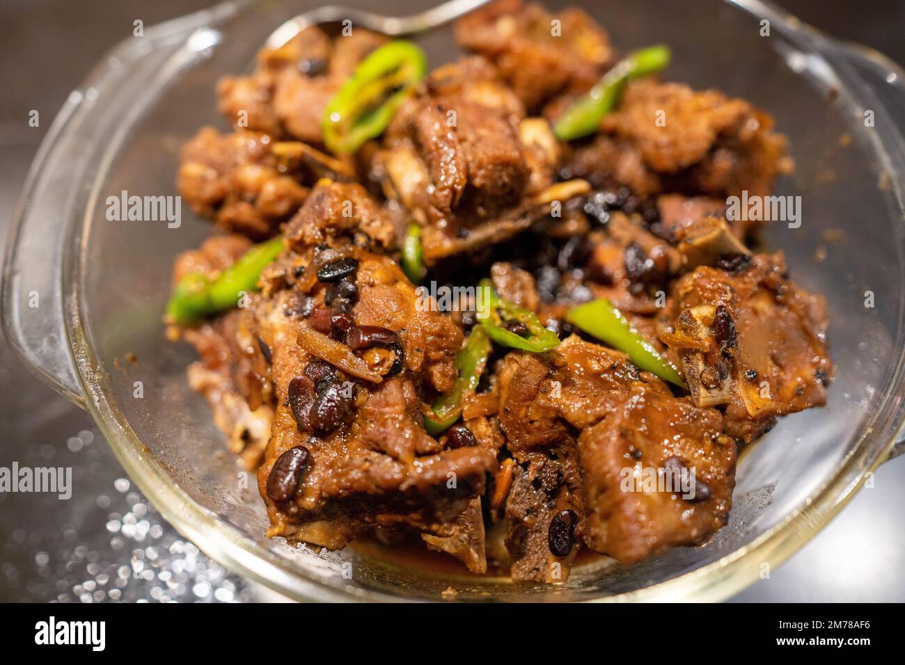 Sweet and sour pork ribs with tausi served in a bowl Stock Photo - Alamy