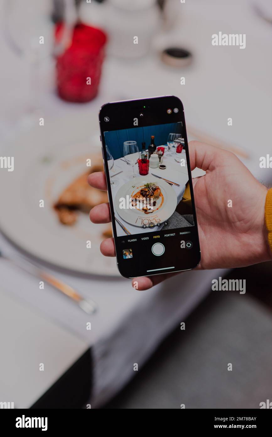 A closeup of a phone taking a photo of Costela Romeu and Julieta on a ...