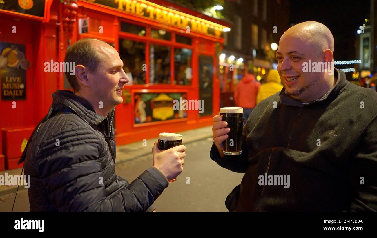 Guys drinking a beer in the Temple Bar district of Dublin by night ...