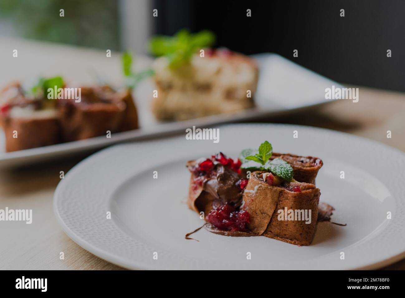 A closeup of a dish white plate and a man holding it blurred background ...