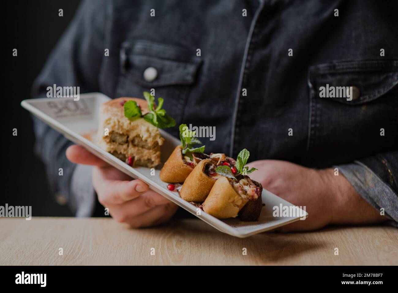 A closeup of a dish white plate and a man holding it blurred background ...