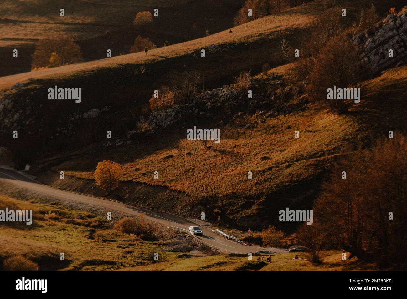 A high-angle of an autumn landscape with sunlit yellow valleys, misty ...