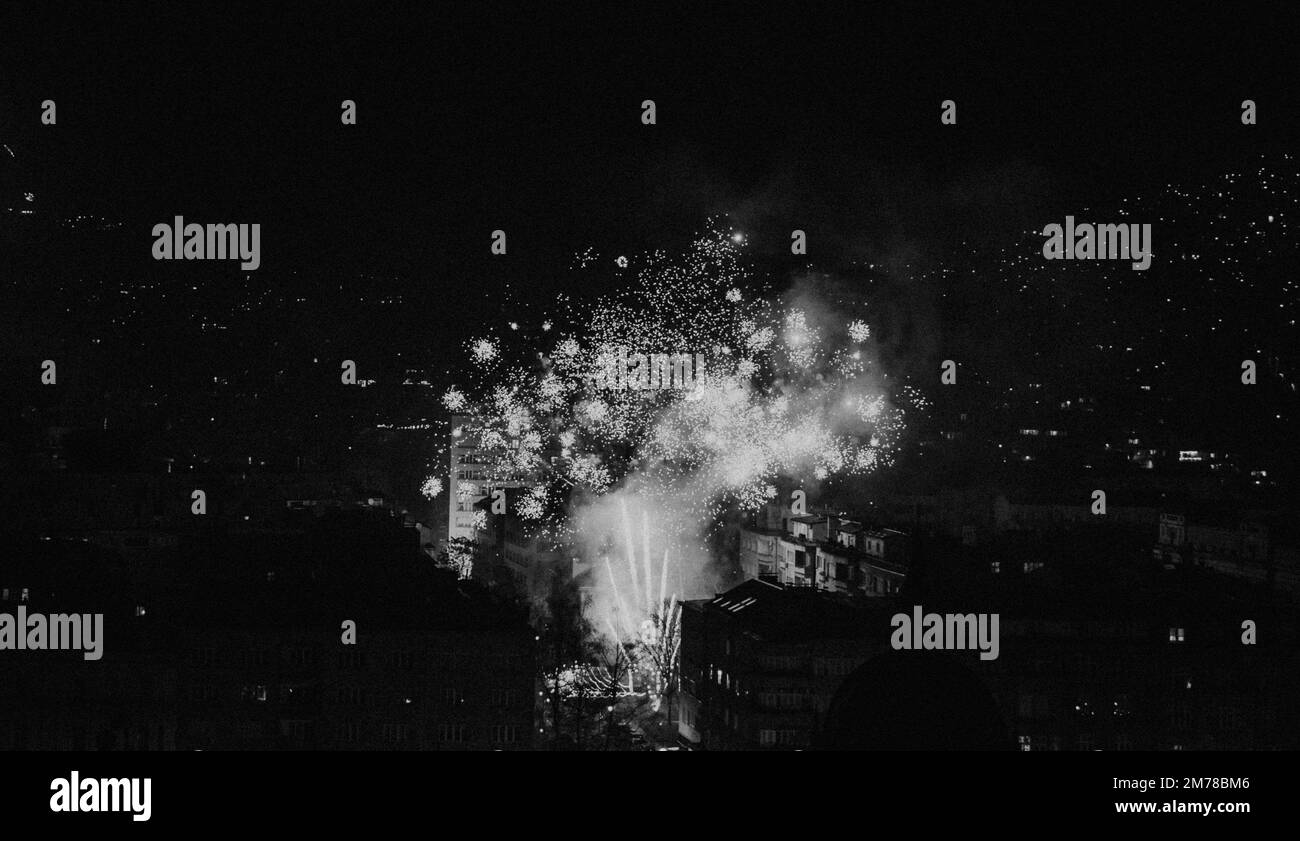 A grayscale of amazing colorful New Year fireworks against dark ...