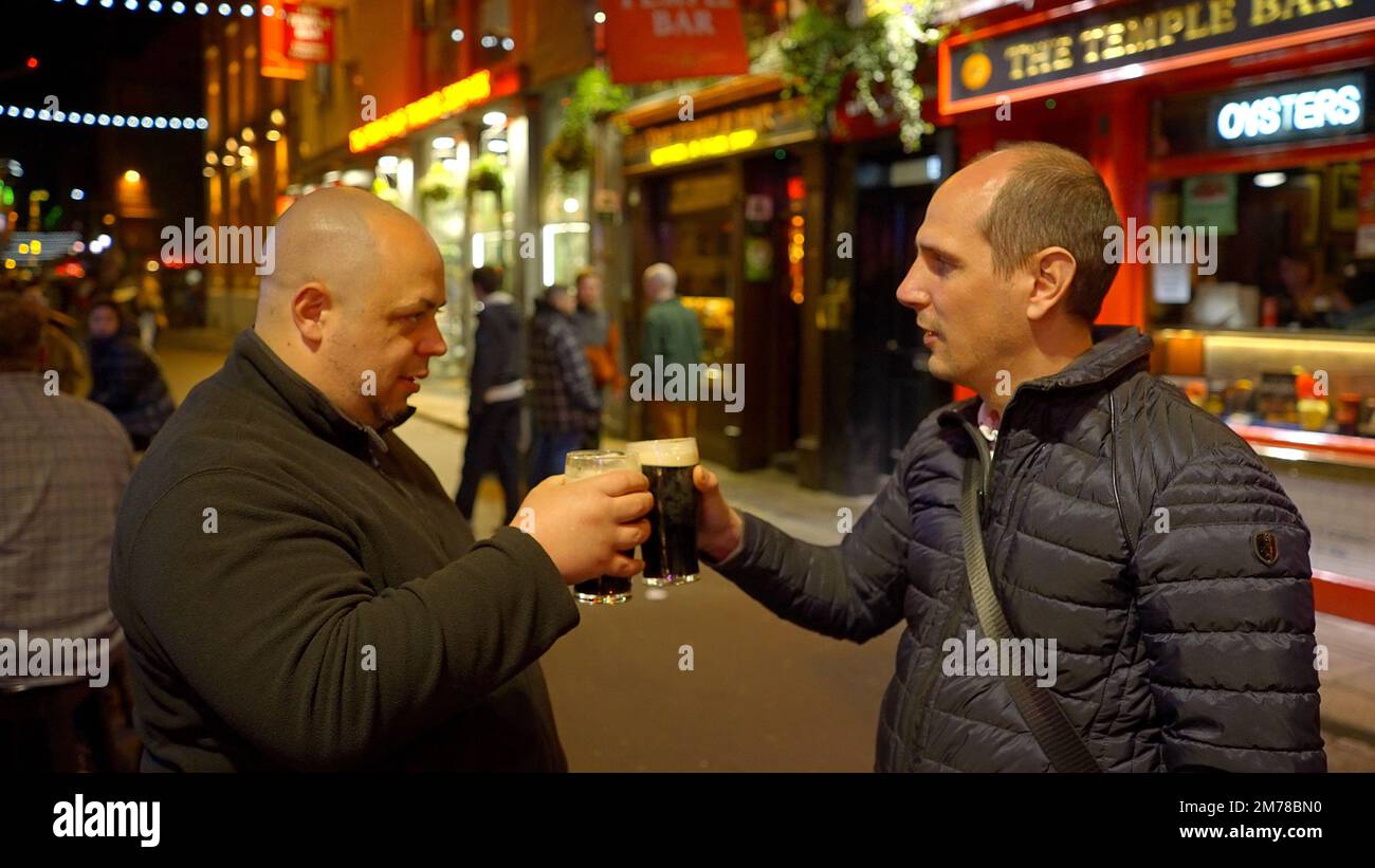 Guys drinking a beer in the Temple Bar district of Dublin by night ...