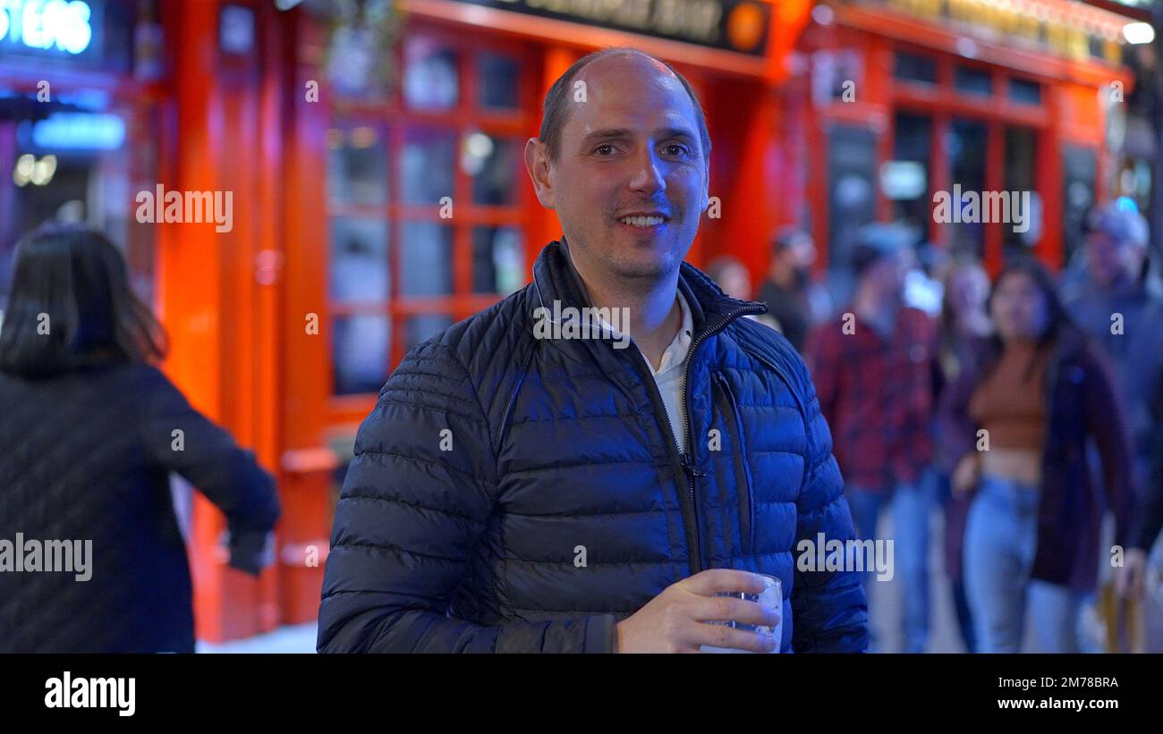 Guys drinking a beer in the Temple Bar district of Dublin by night ...
