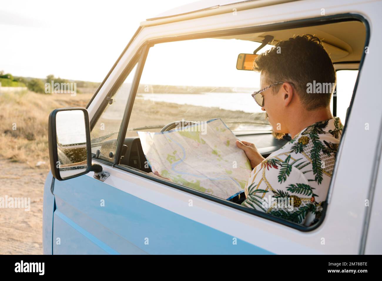 Rear view of a man using a map while driving a camper van Stock Photo ...
