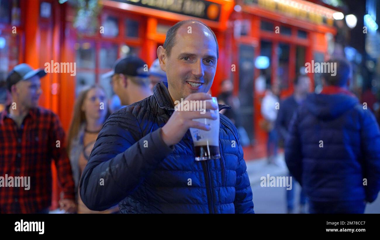 Guys drinking a beer in the Temple Bar district of Dublin by night ...