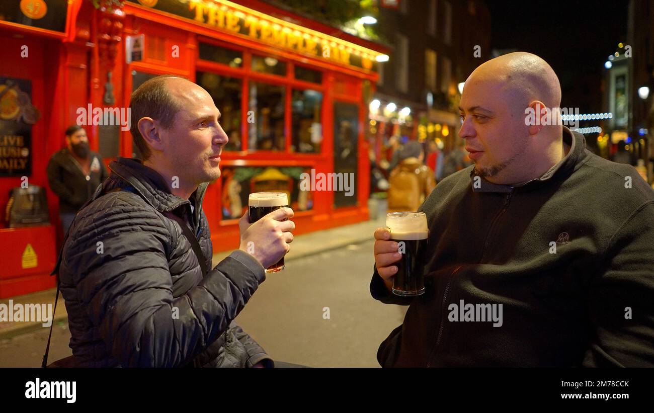 Guys drinking a beer in the Temple Bar district of Dublin by night ...