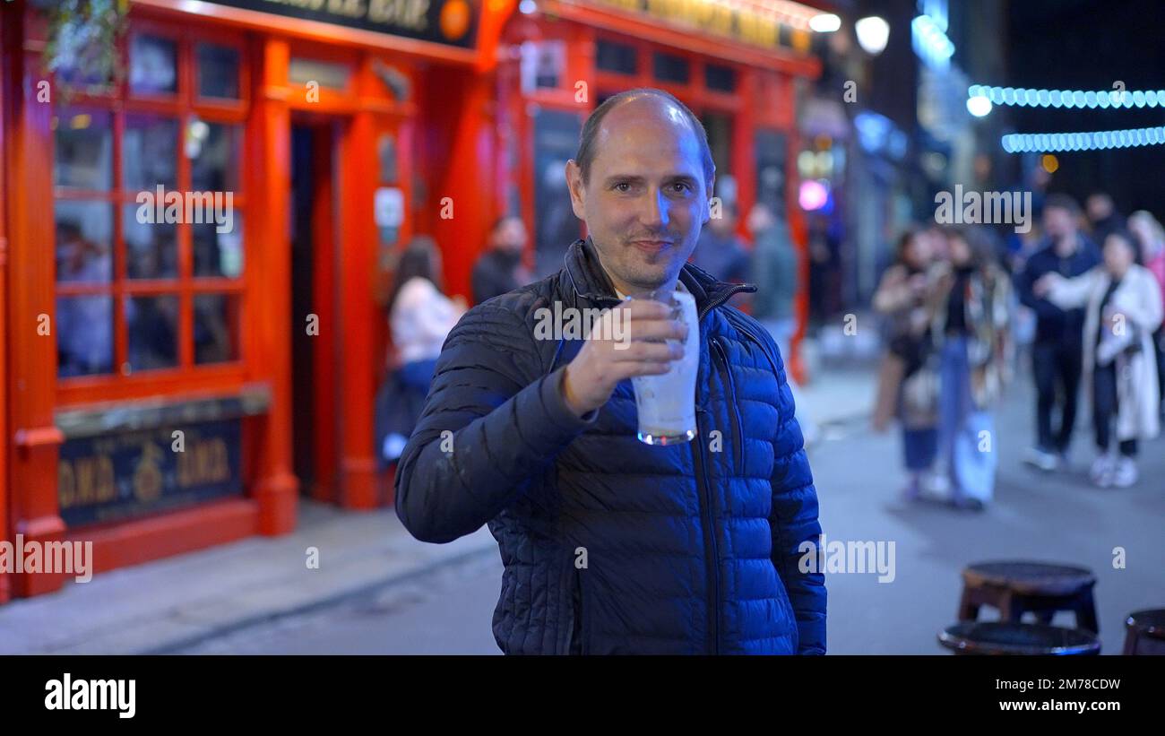 Guys drinking a beer in the Temple Bar district of Dublin by night ...
