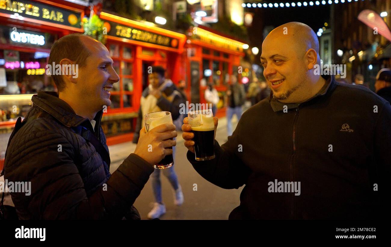 Guys drinking a beer in the Temple Bar district of Dublin by night ...