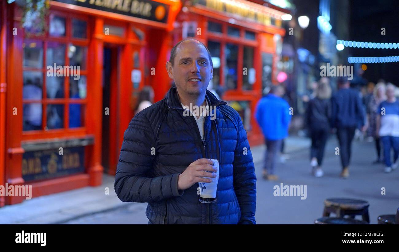 Guys drinking a beer in the Temple Bar district of Dublin by night ...