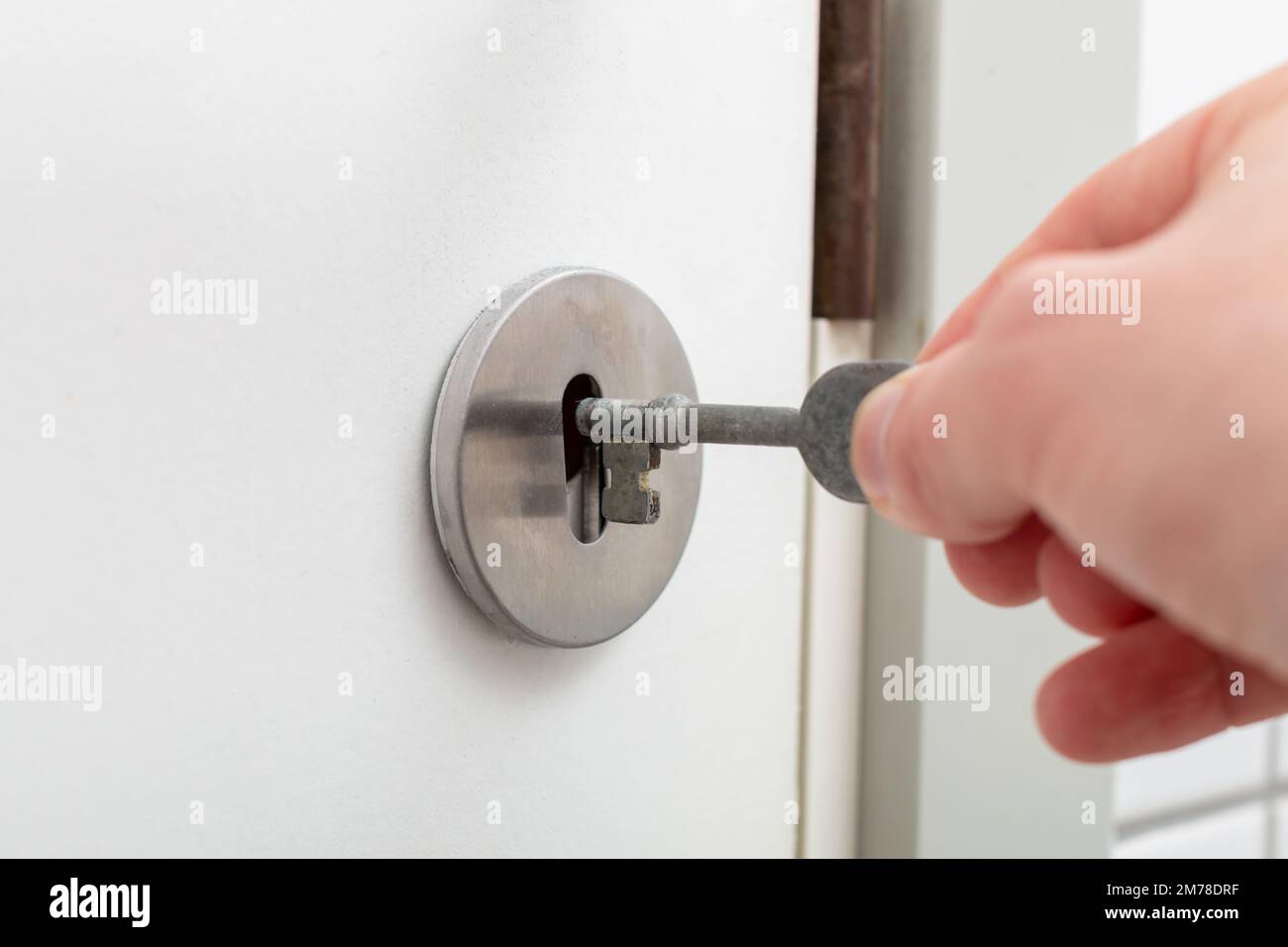 Hand inserts the key in to the bathroom doors Stock Photo - Alamy