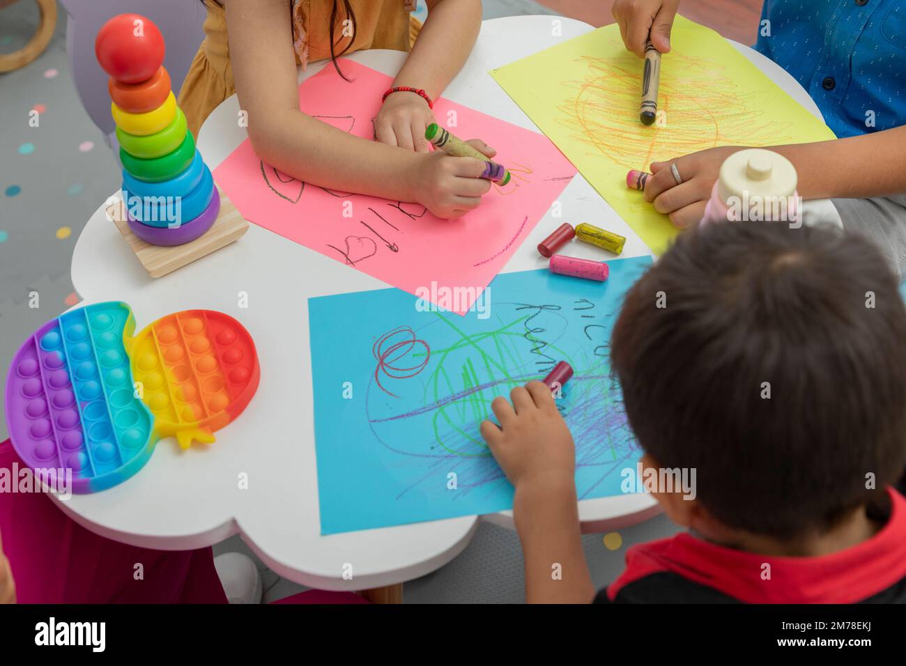 Children's hands drawing on colored sheets, on a preschool table Stock ...