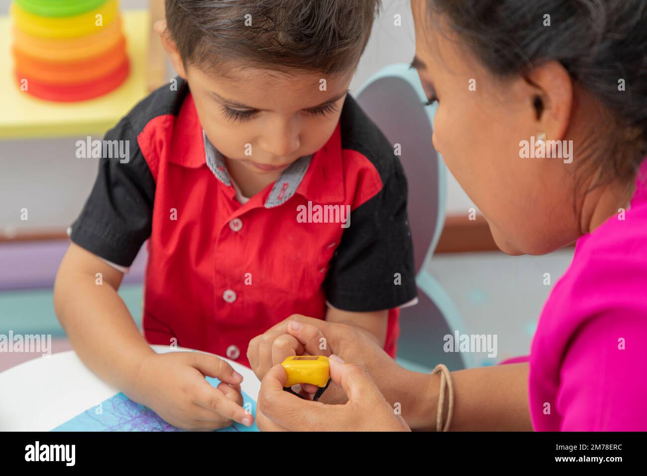 Female pediatrician doctor checking a child with an oximeter in her ...