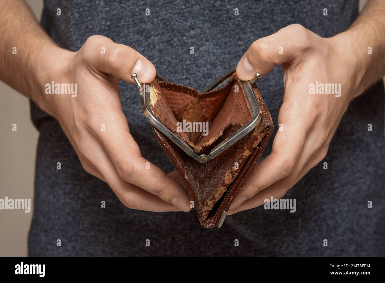 An empty wallet in the hands of a young man, the concept of bankruptcy and financial crisis ...