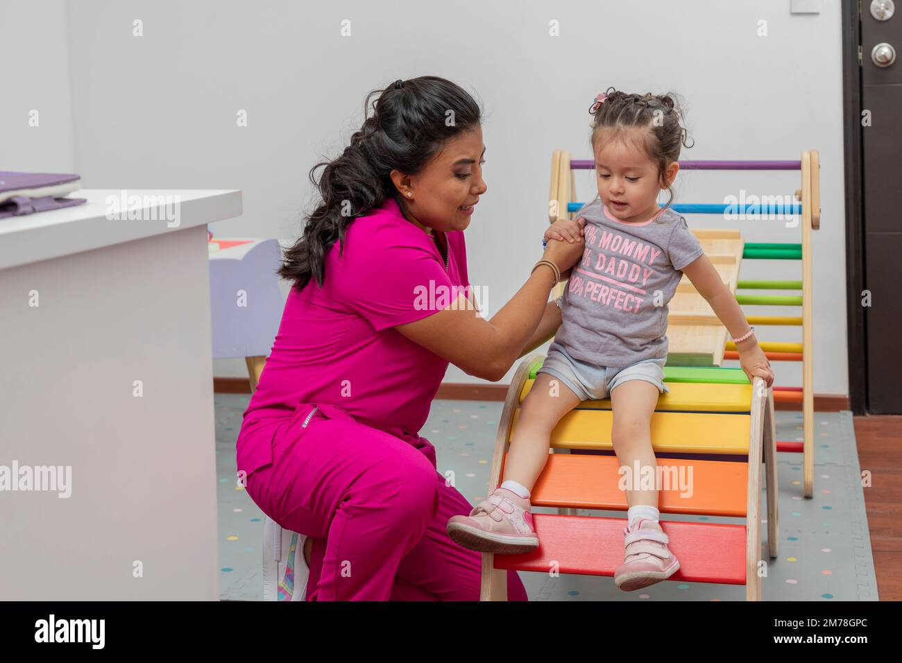 Pediatric doctor plays with a girl in the playground of her medical ...