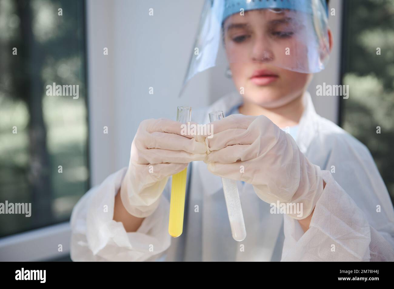 Details: hands of a smart choolboy, holding test tubes with chemicals ...