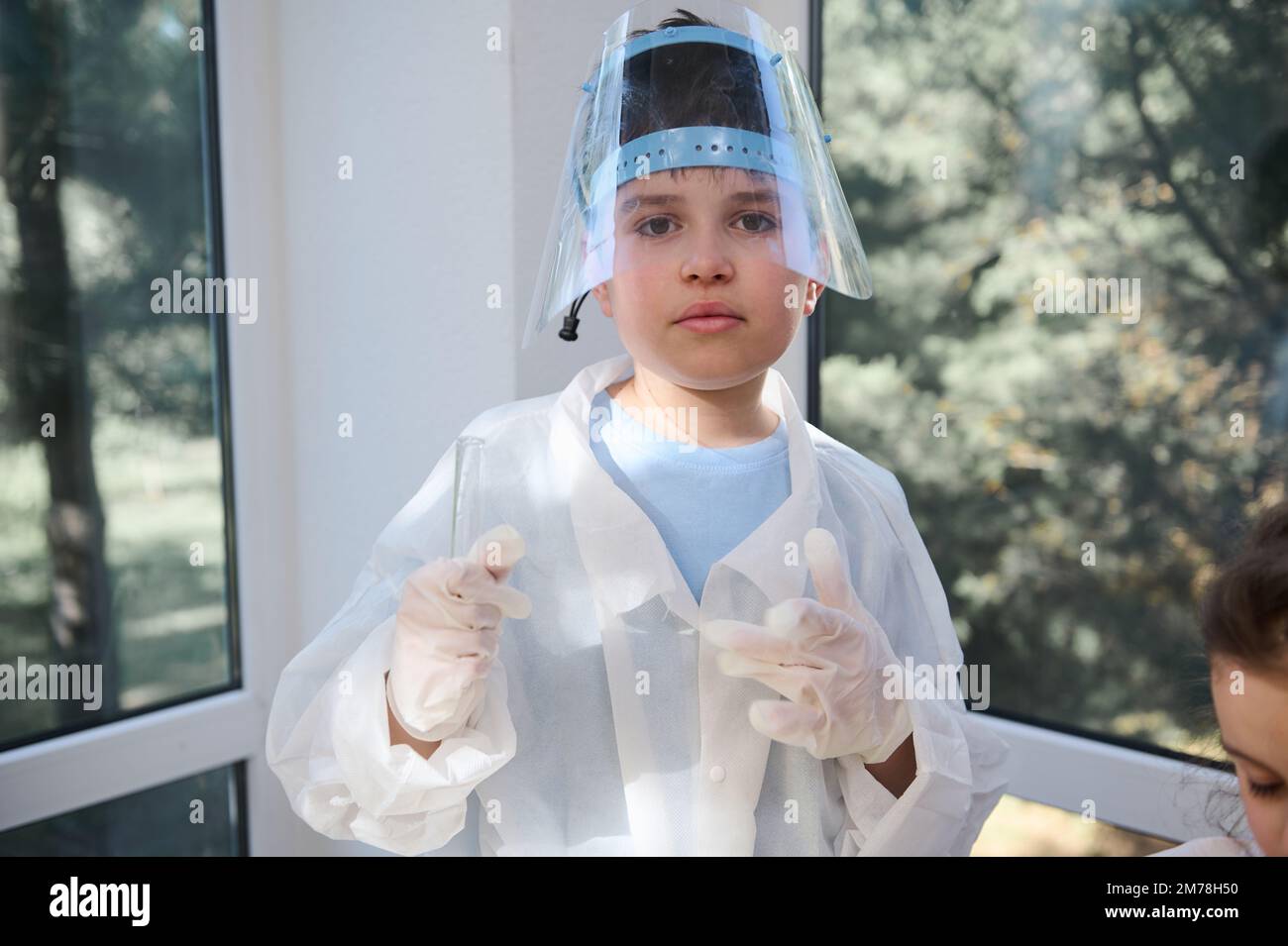 Close-up handsome smart teenage boy, wearing protective lab wear ...