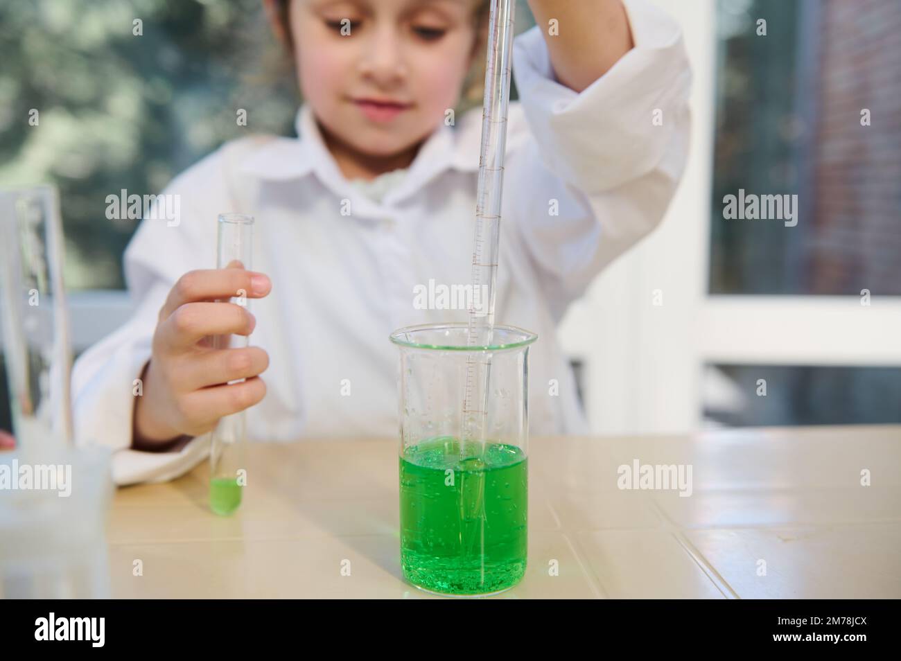 Selective focus on a beaker with green chemical liquid and graduated ...