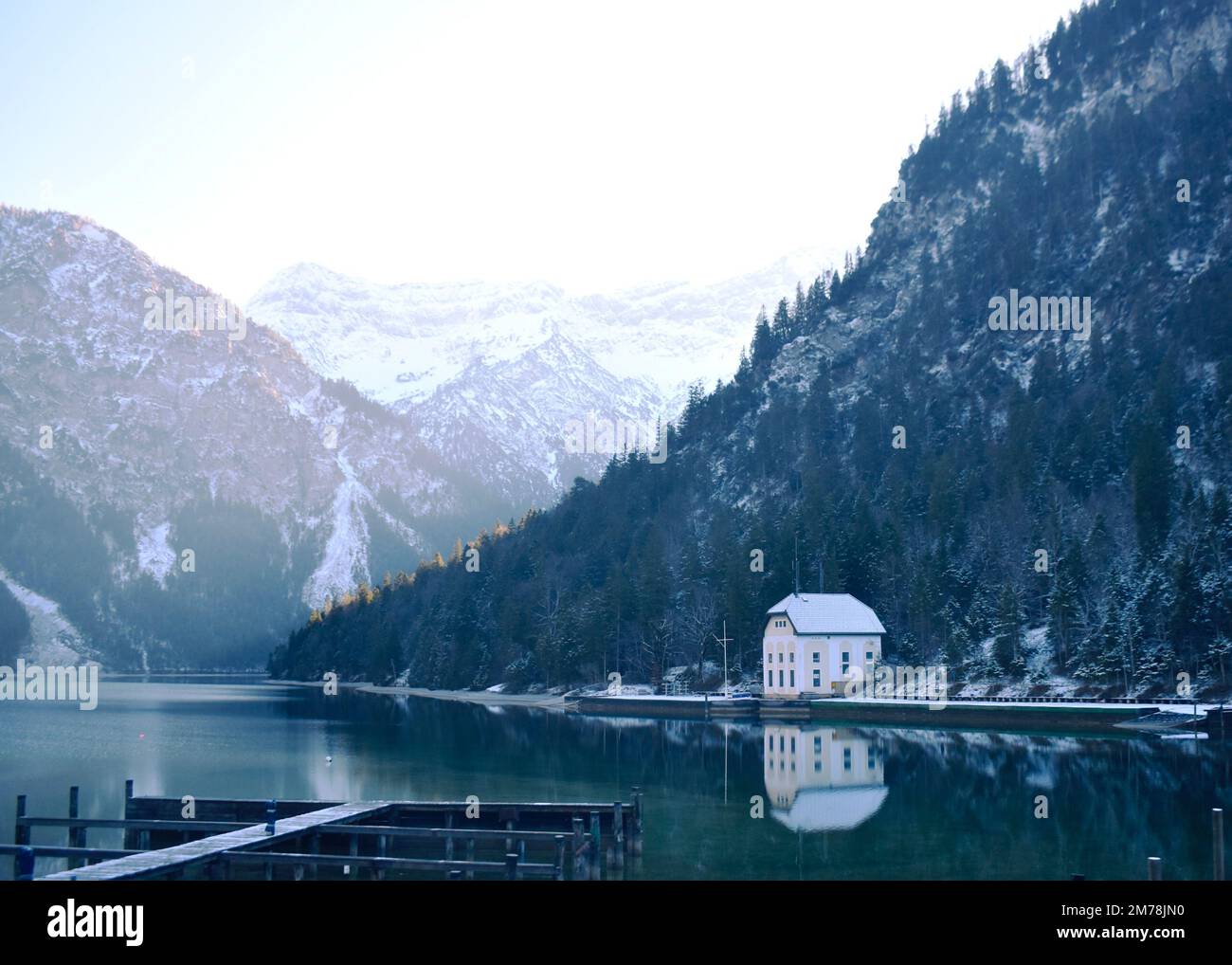A reflection of a lakeside house on the scenic mirror lake Plansee ...