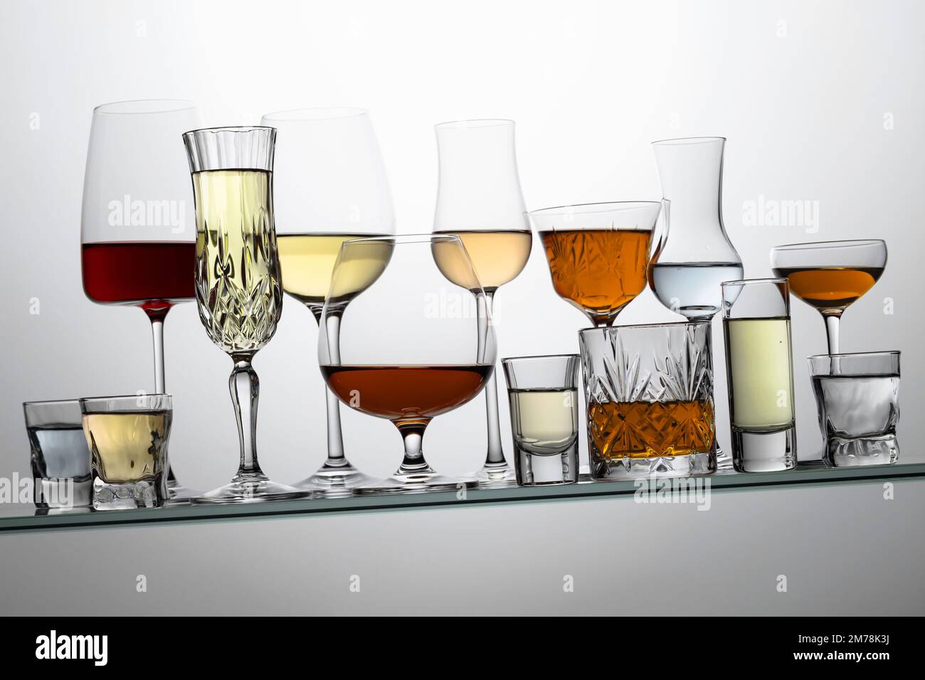 Various alcoholic drinks in a bar on a tilted glass shelf Stock Photo ...